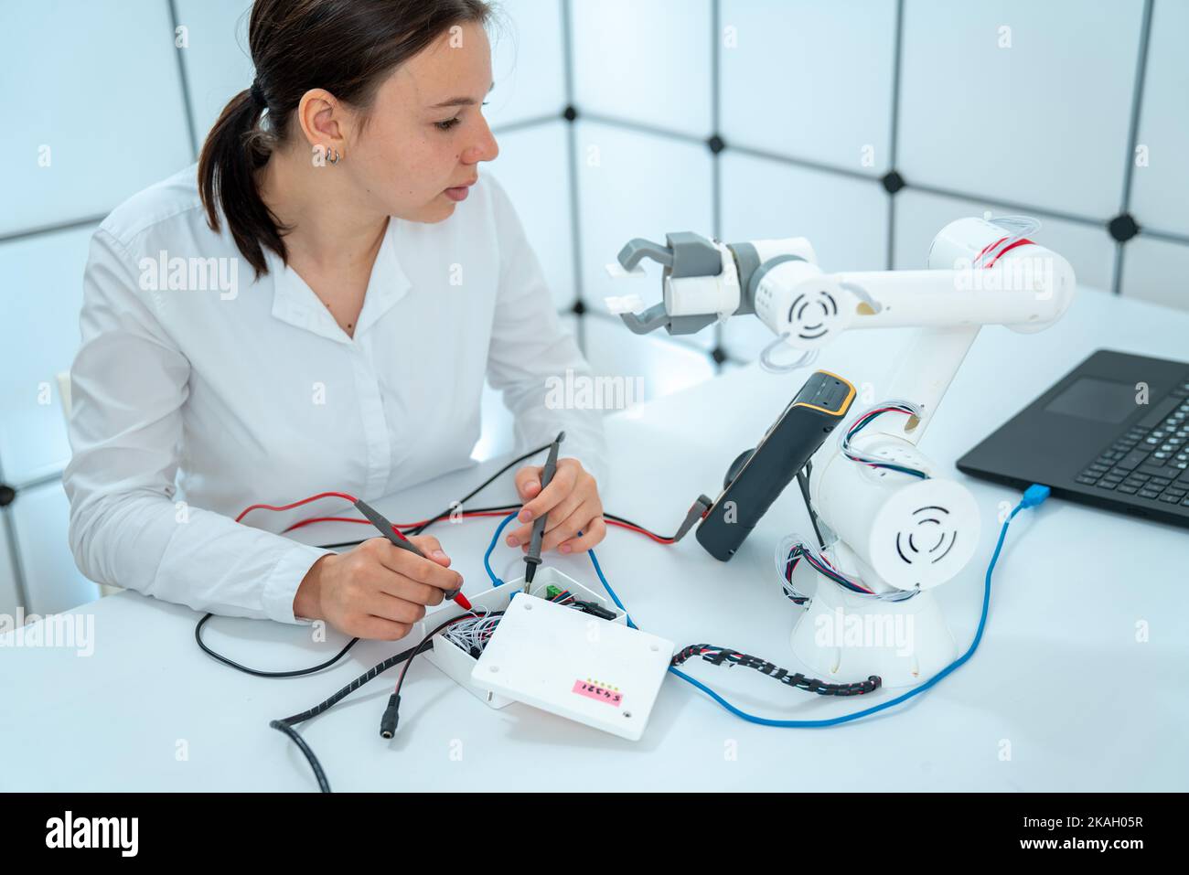 female student of the Technical University explores an industrial robot ...