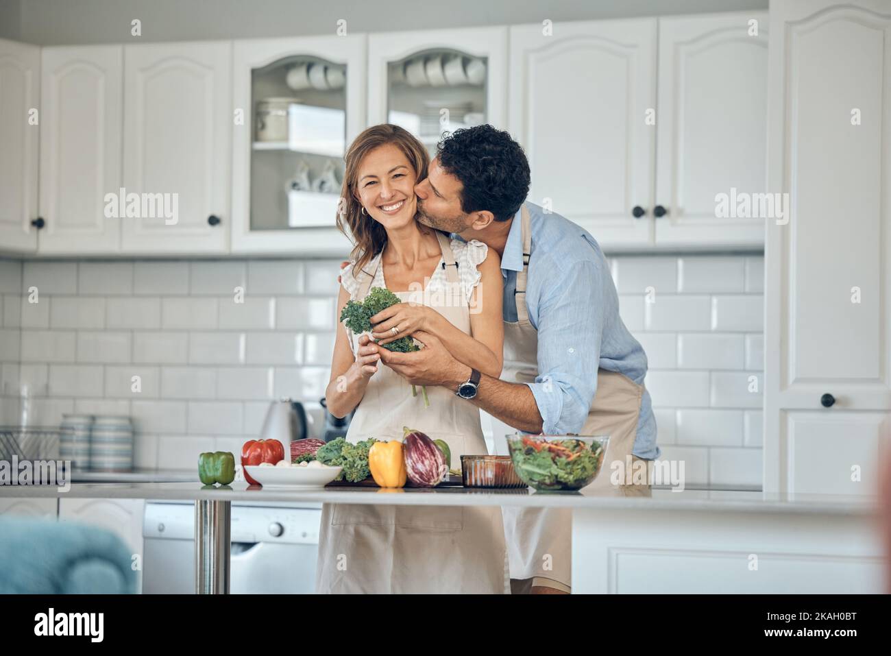 Food, love and elderly couple in kitchen, kiss and hug while prepare ...