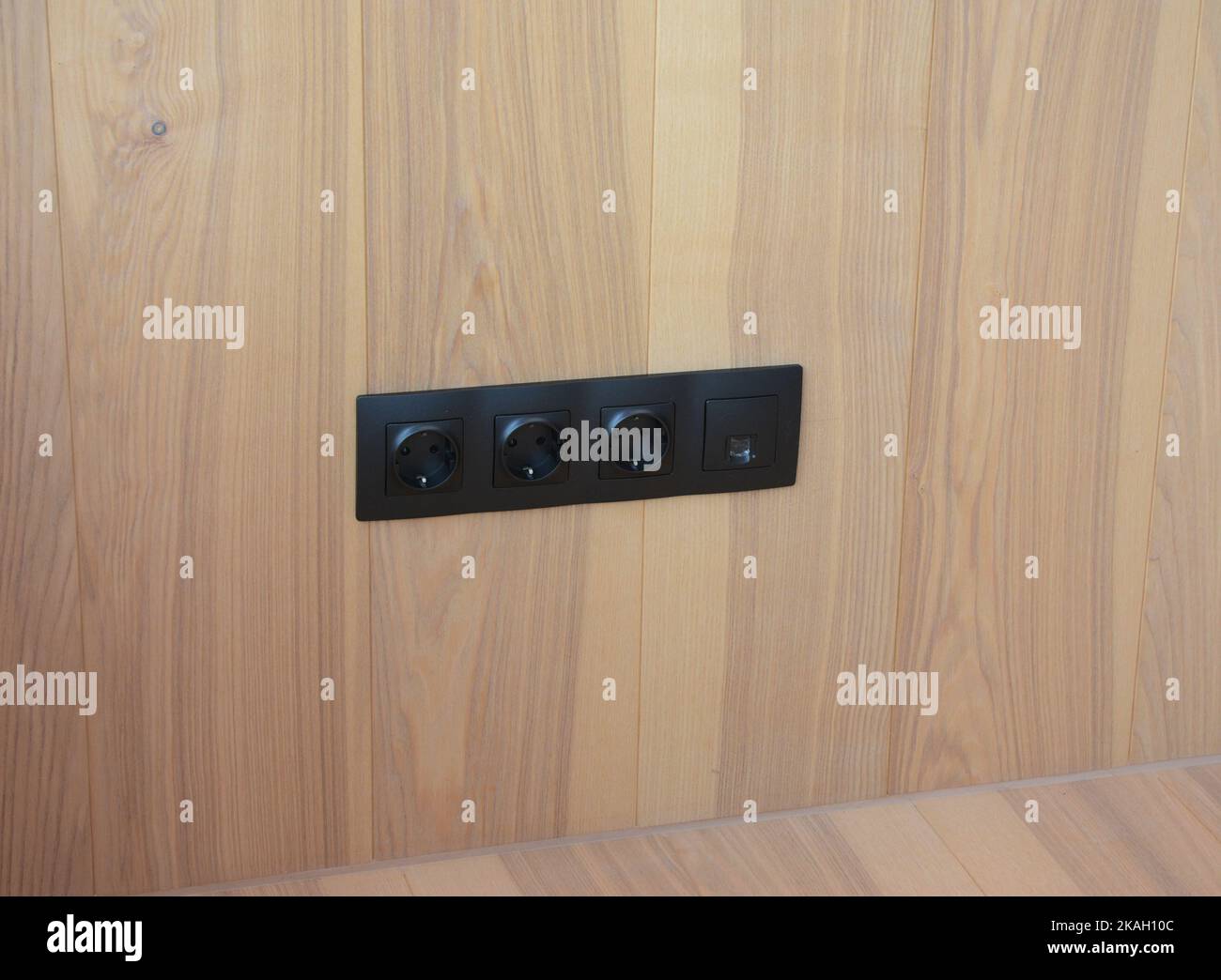 Black outlet plug on the modern wooden wall. Socket, european power ...