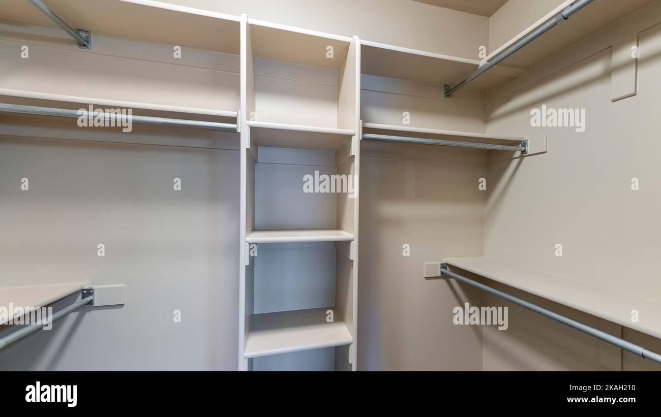 Panorama Small empty walk-in closet with shelves and metal rods ...