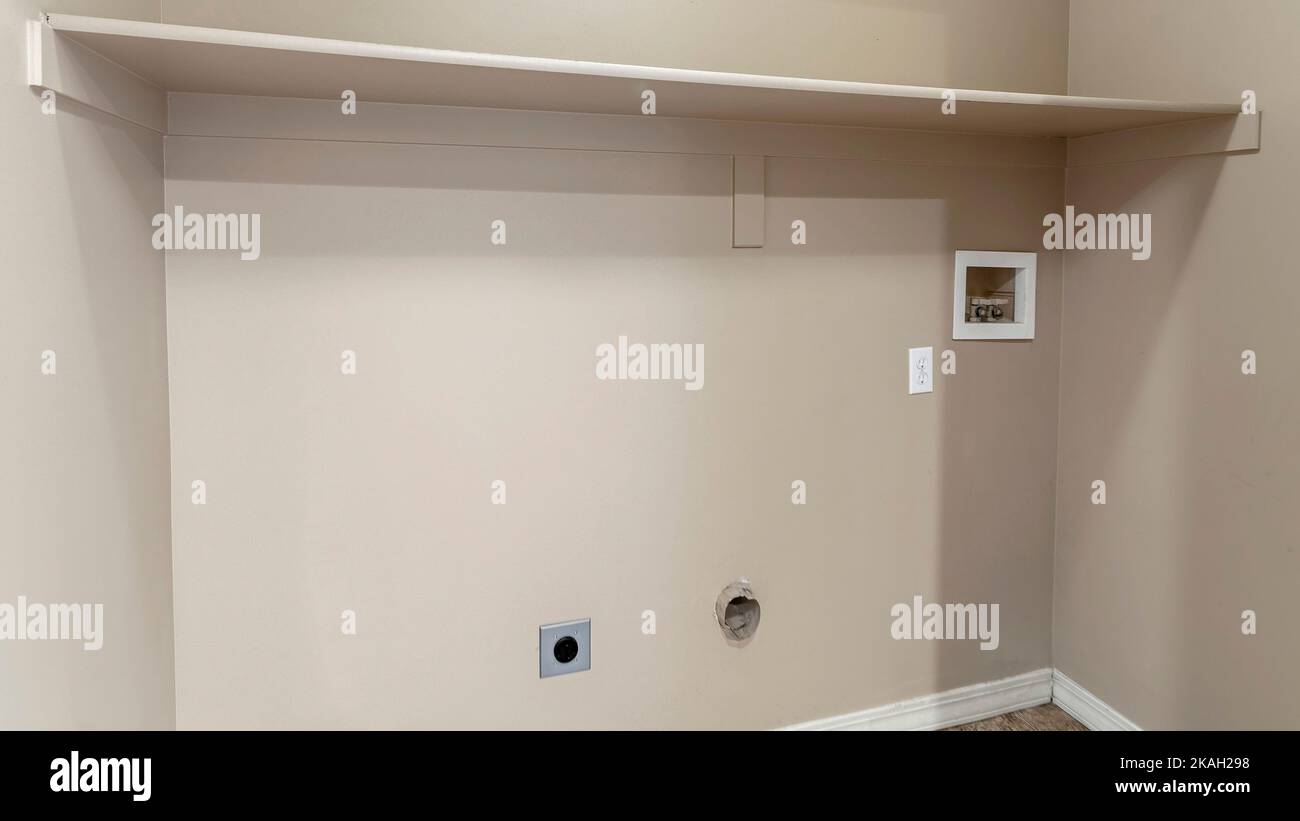 Panorama Empty laundry room interior with wall mounted shelf. There are ...