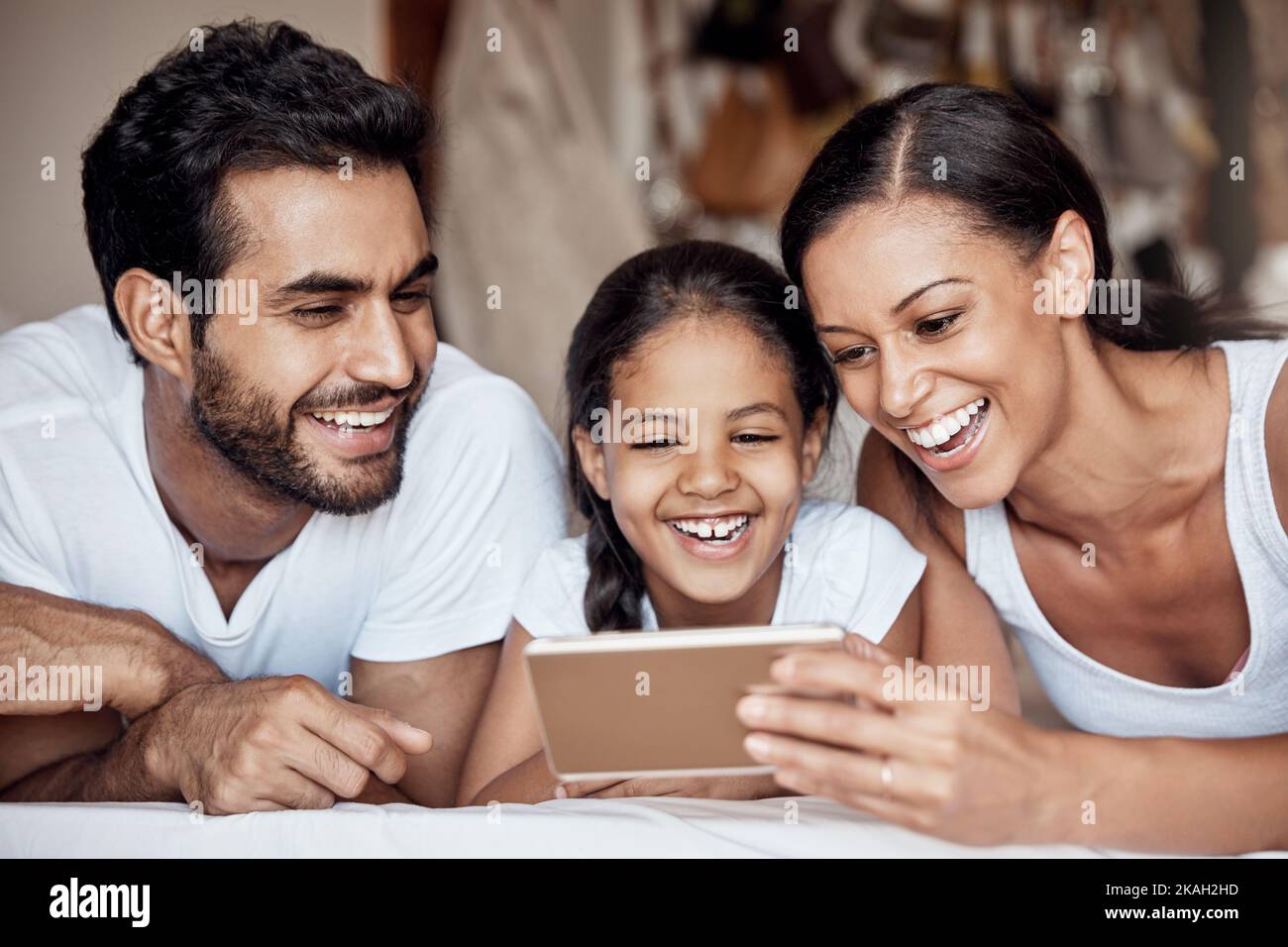 Theyre a connected family. a happy family using a cellphone together at ...