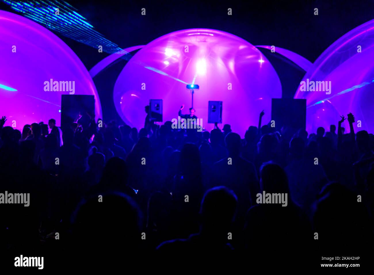 Crowd of unrecognizable people dancing and clapping hands while ...