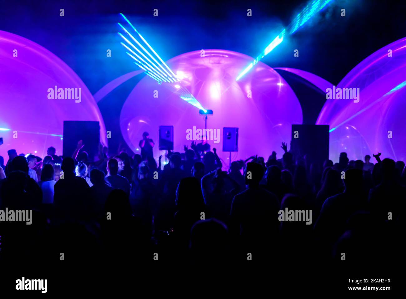 Crowd of unrecognizable people dancing and clapping hands while ...