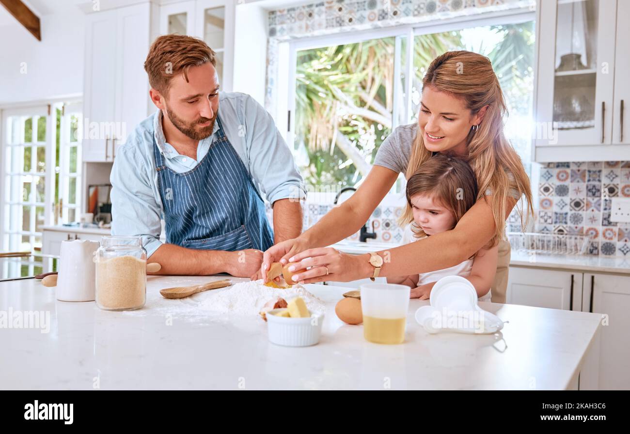 Baking, child and parents teaching a child to bake in the kitchen of a ...