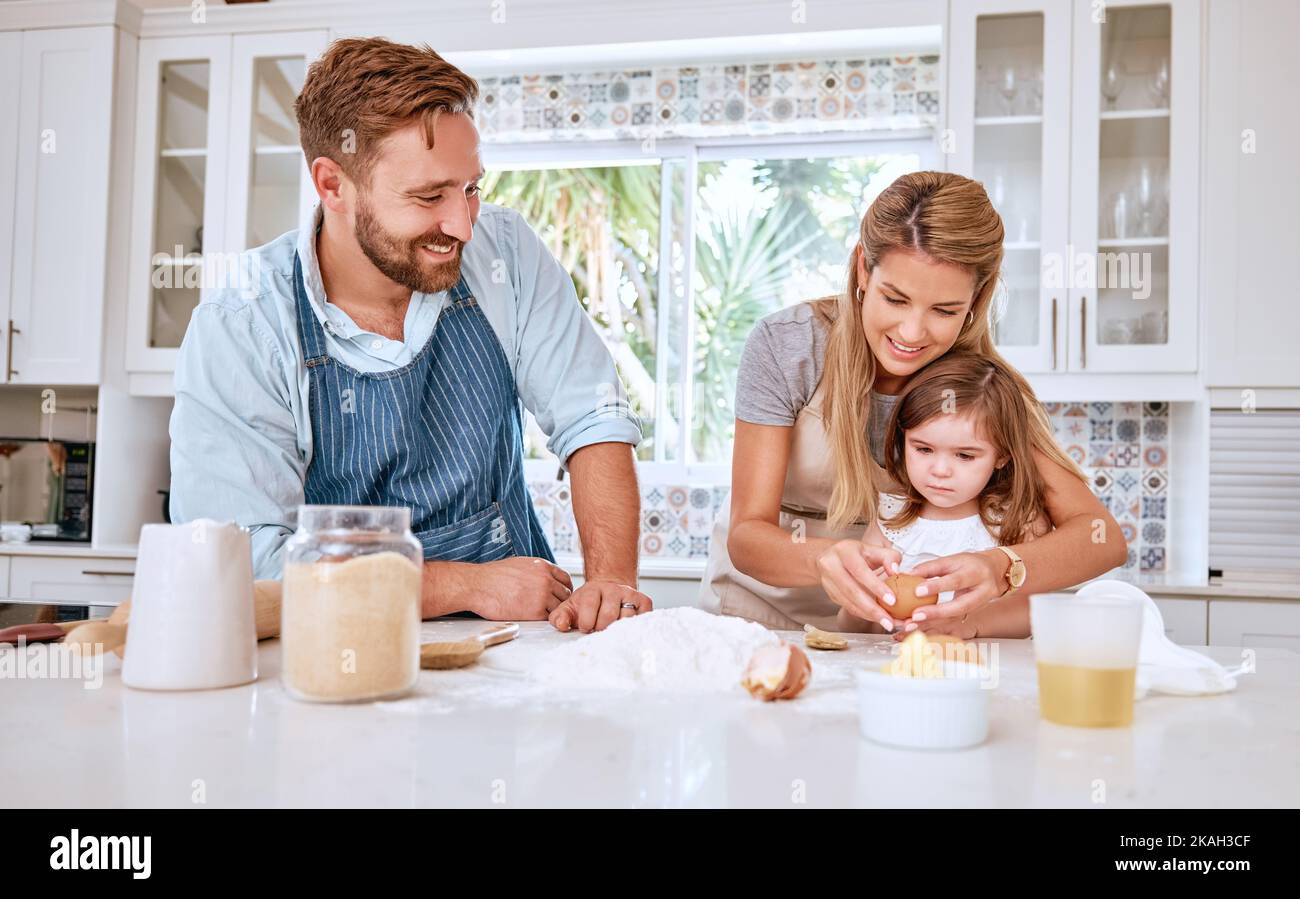 Mother, father and girl cooking and baking in kitchen having fun ...