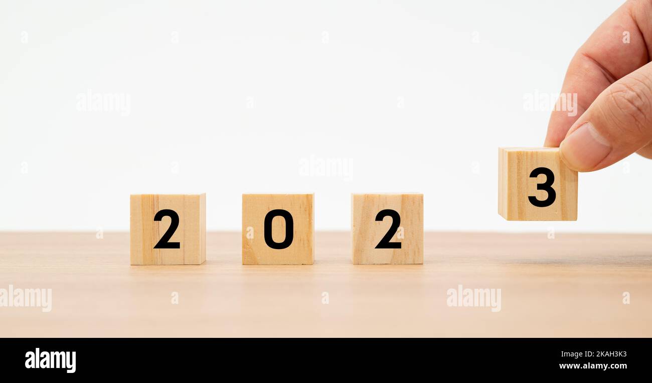 A man holding a flip block with 2023 numbers in the white background ...