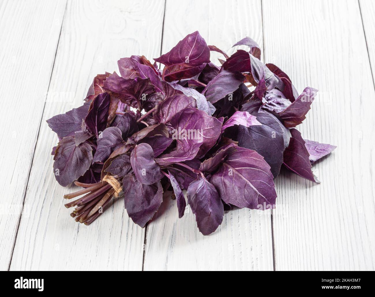 Fresh purple basil leaves on white wooden background Stock Photo - Alamy