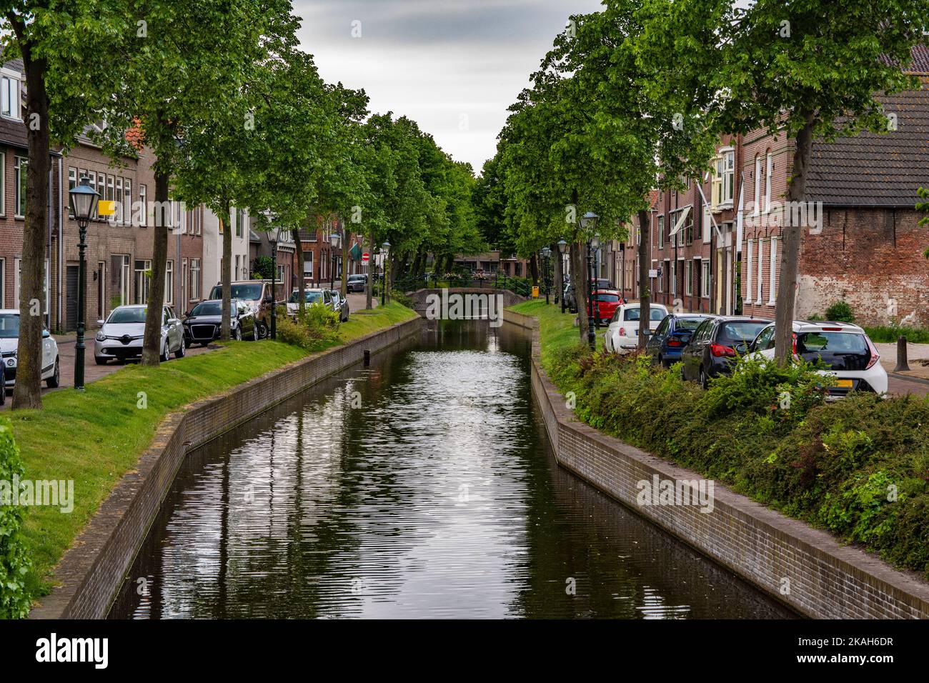 Road and brick houses by a canal in the Netherlands. Summer ...