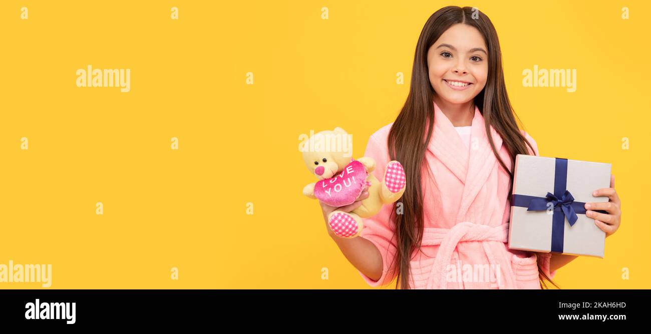 Teenager birthday. happy teen girl in home terry bathrobe with toy and ...