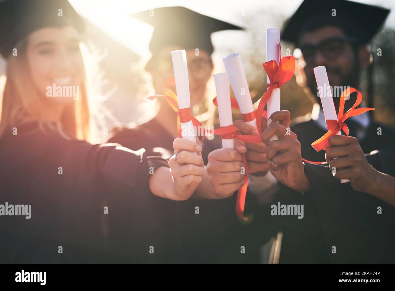 Just graduated. a group of students holding their diplomas together on ...