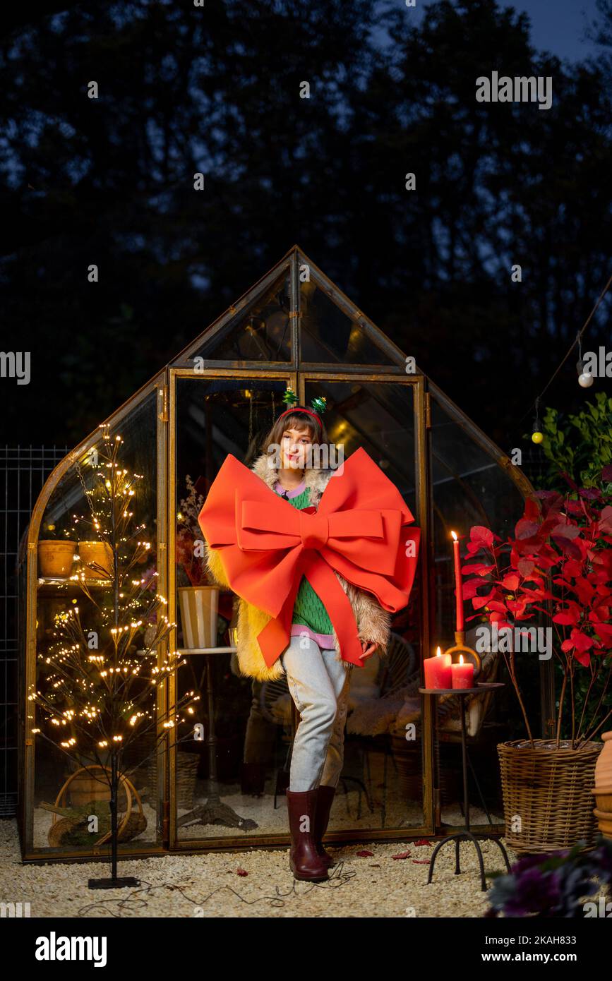 Woman with big festive red bow at backyard Stock Photo - Alamy