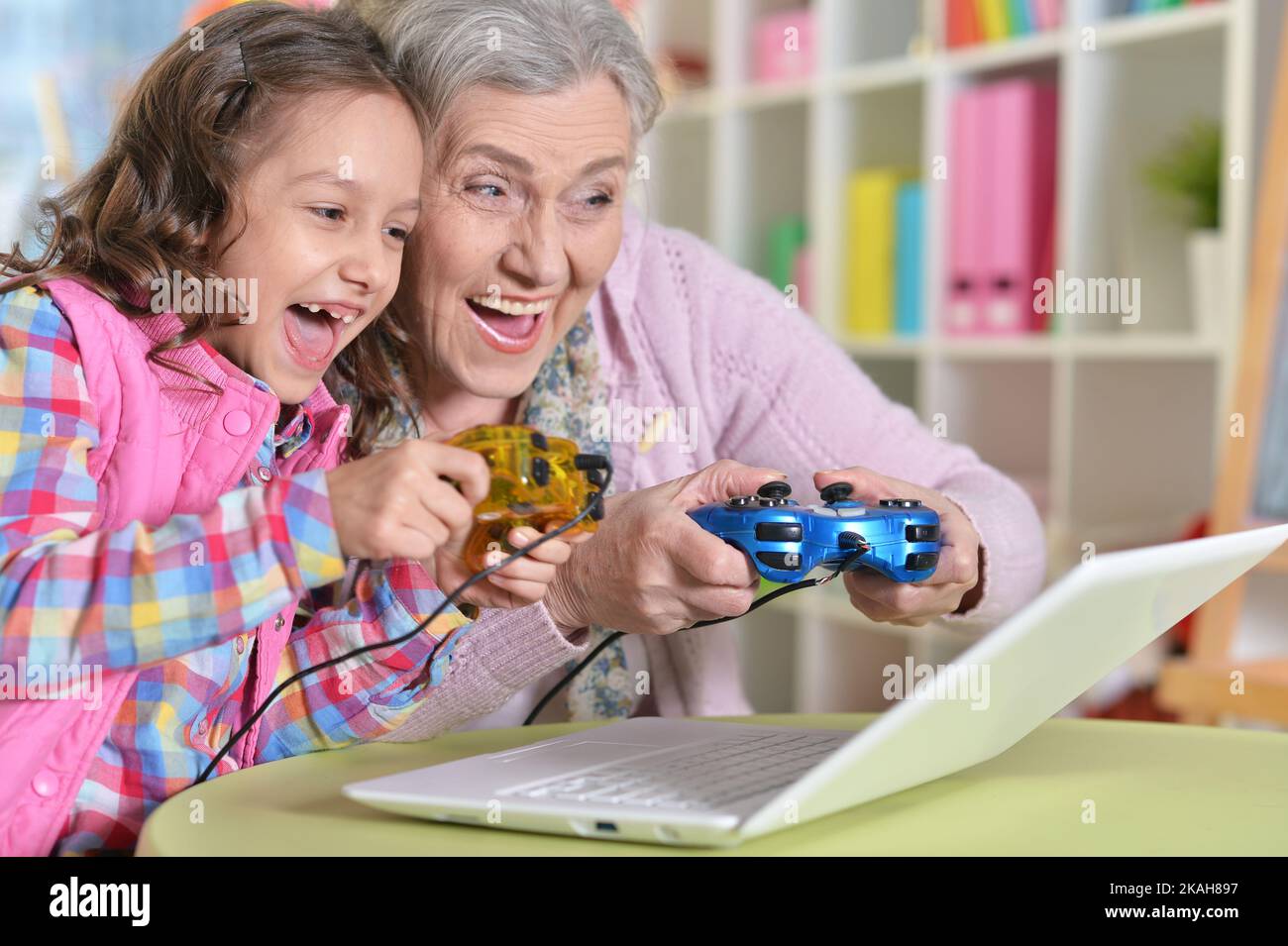 little girl with grandmother playing computer game Stock Photo - Alamy