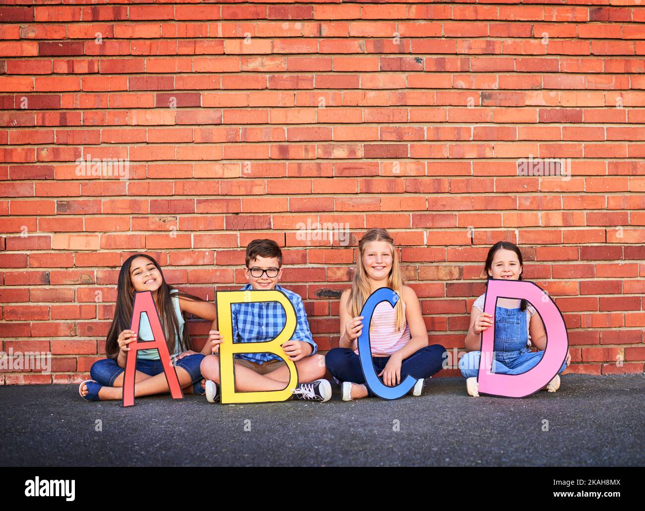 Children holding alphabet letters hi-res stock photography and images ...