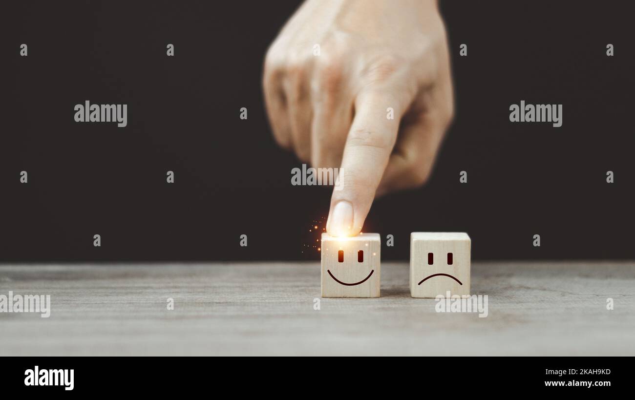 Close up customer hand choose smiley face and blurred sad face icon on ...