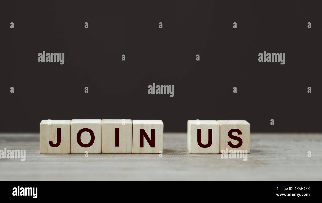 Join us word on wooden blocks on wood table. Copy space. dark ...