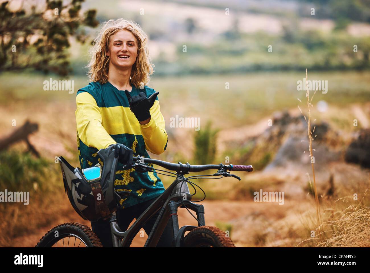 Sports, bike and cyclist man hand sign in nature on a park trail with a ...