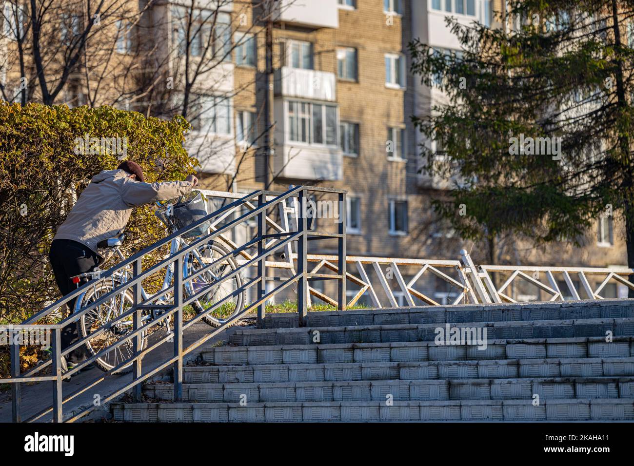 Novomoskovsk, Russia - October 25, 2022: man lifts bike up stairs Stock ...