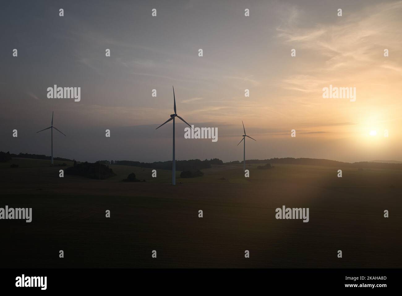 Aerial, scenic view of wind power plant silhouette against sunset ...
