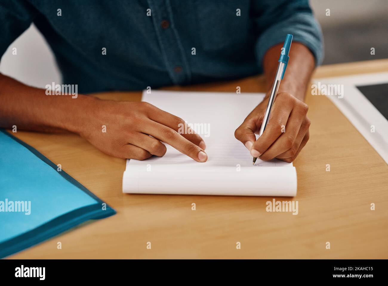 Making study notes. High angle shot of a young and unrecognizable male ...