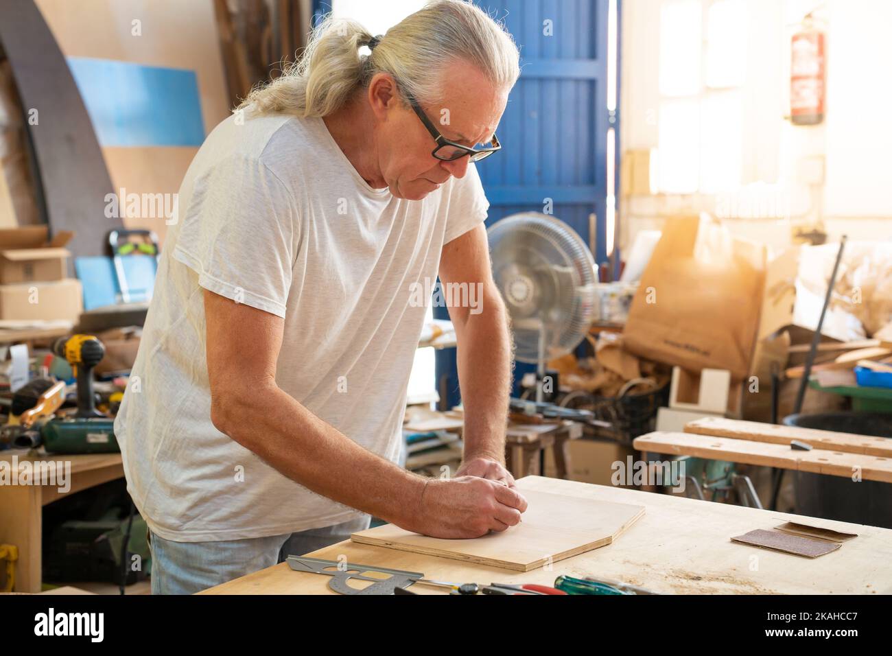 Carpenter working on wood craft at workshop producing wooden furniture ...