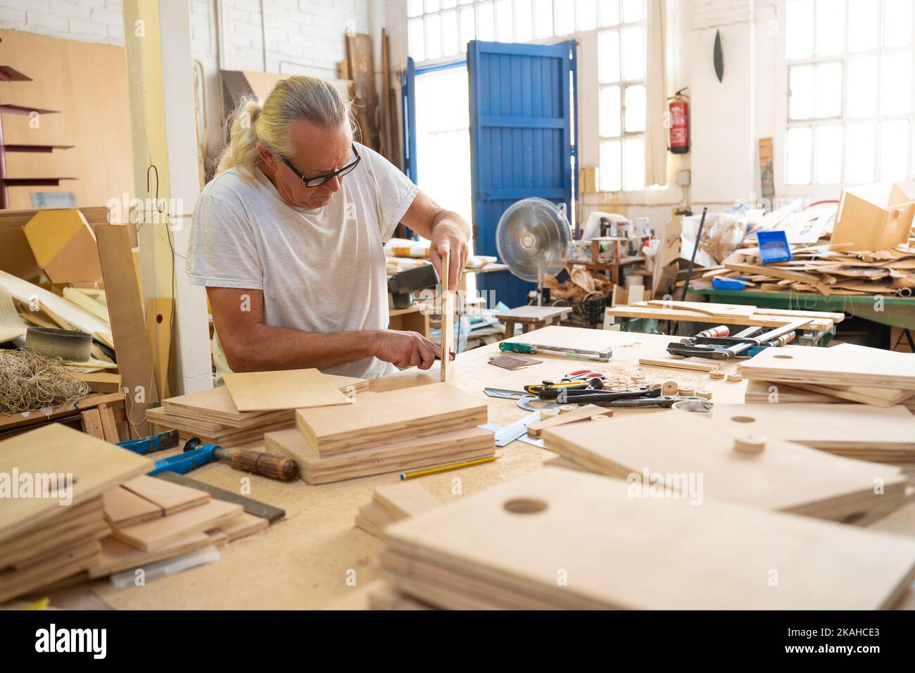 Senior carpenter working on wood craft at workspace producing wooden ...