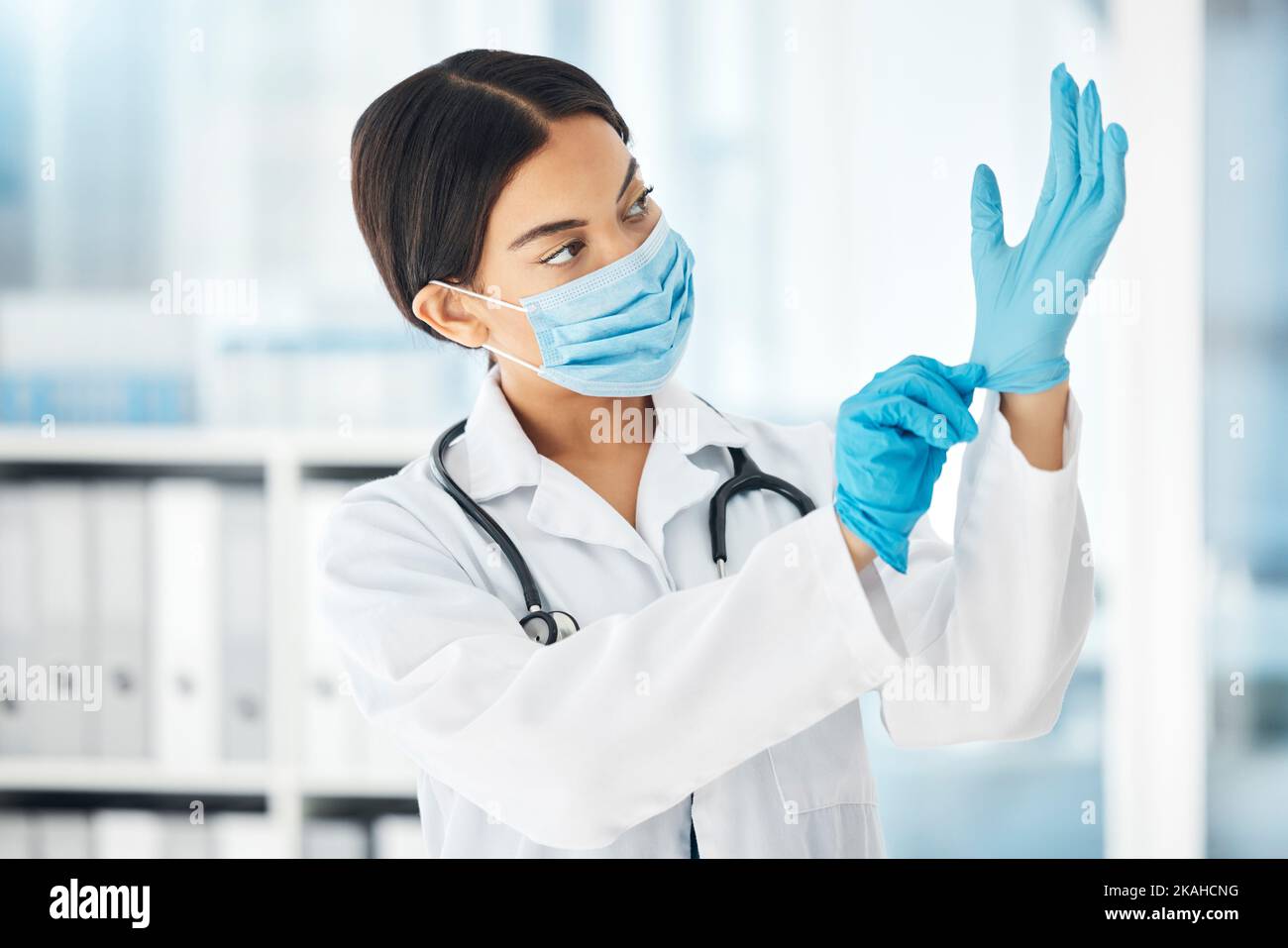 Healthcare, covid and a doctor putting gloves on hands, woman ready for ...