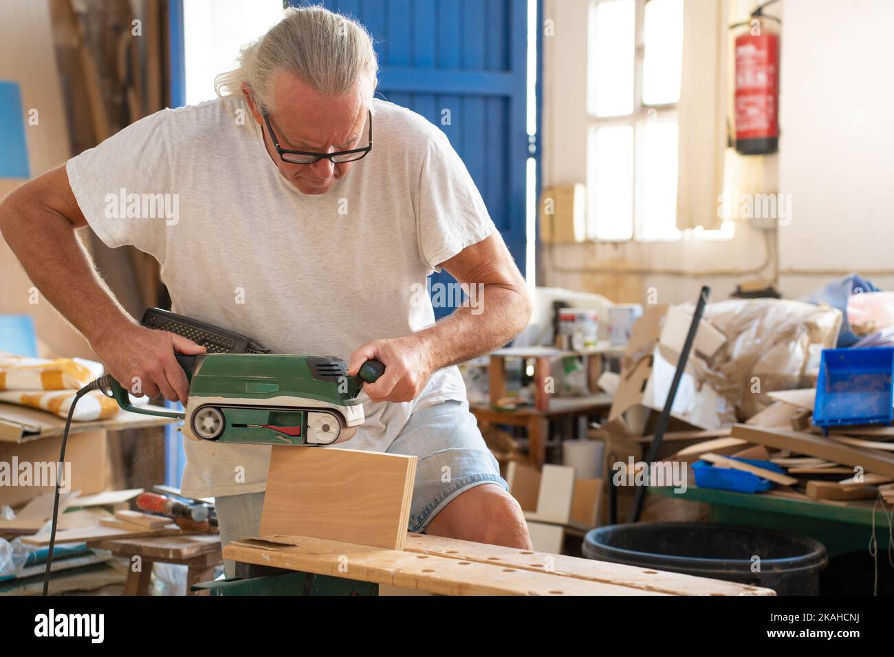 Senior carpenter working on wood craft at workspace producing wooden ...