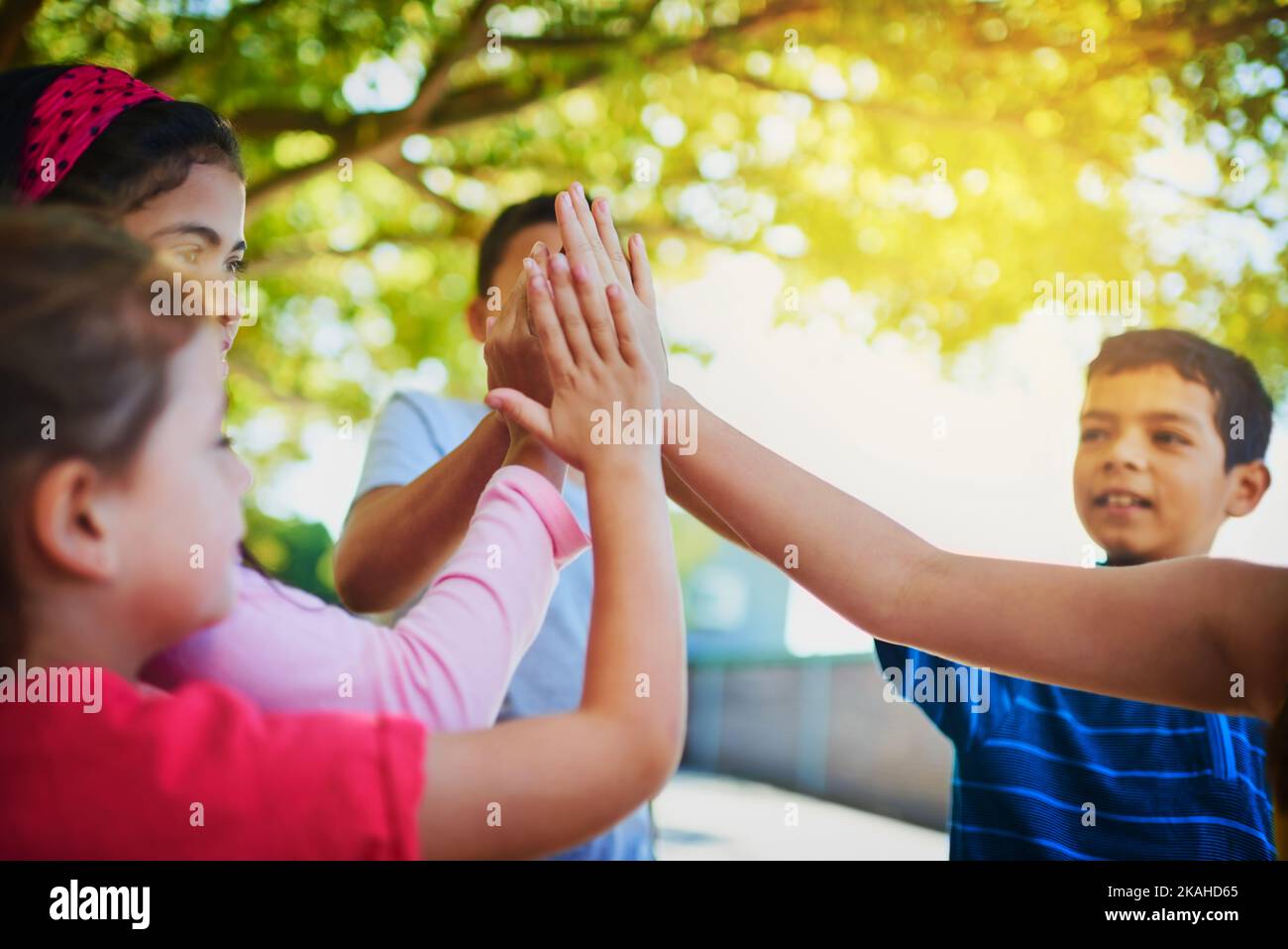 High five for being on holiday. a diverse group of young friends giving ...