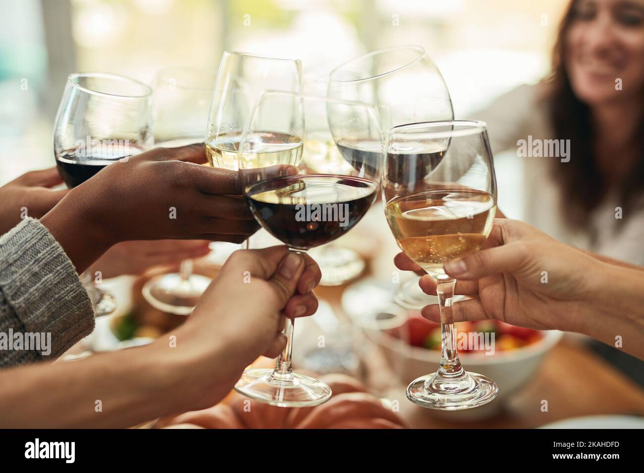 Heres to the good times. a group of people making a toast at a dining ...