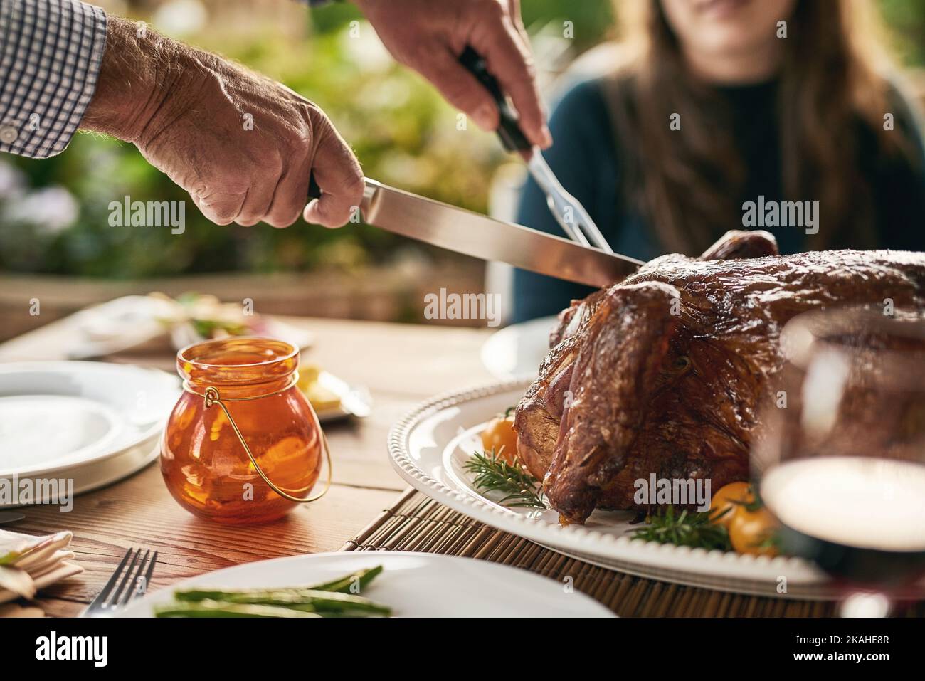 Who wants the first piece. a unrecognizable person cutting up a roast ...