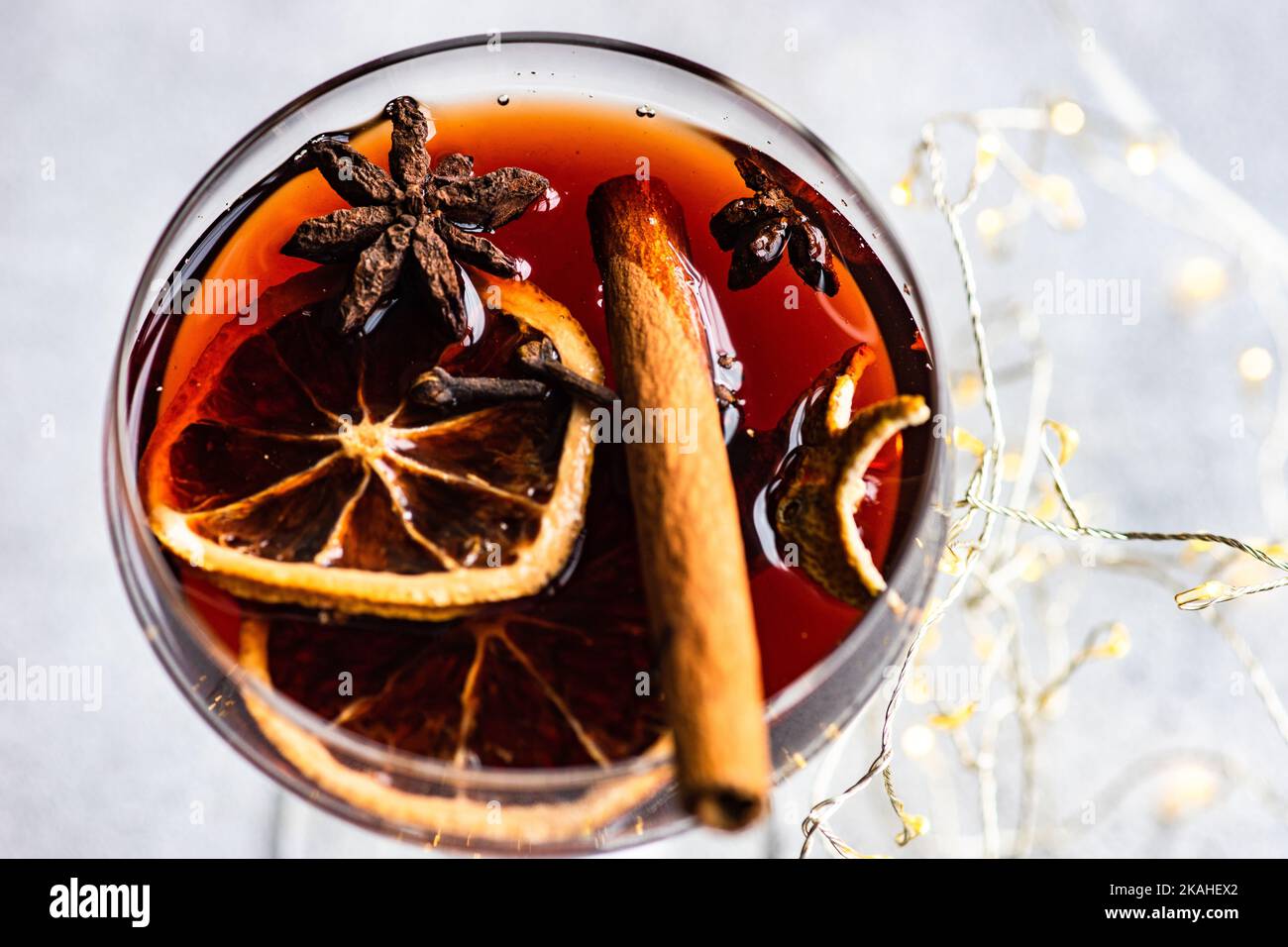 Glass of mulled wine with dried orange slices, cinnamon sticks and star ...