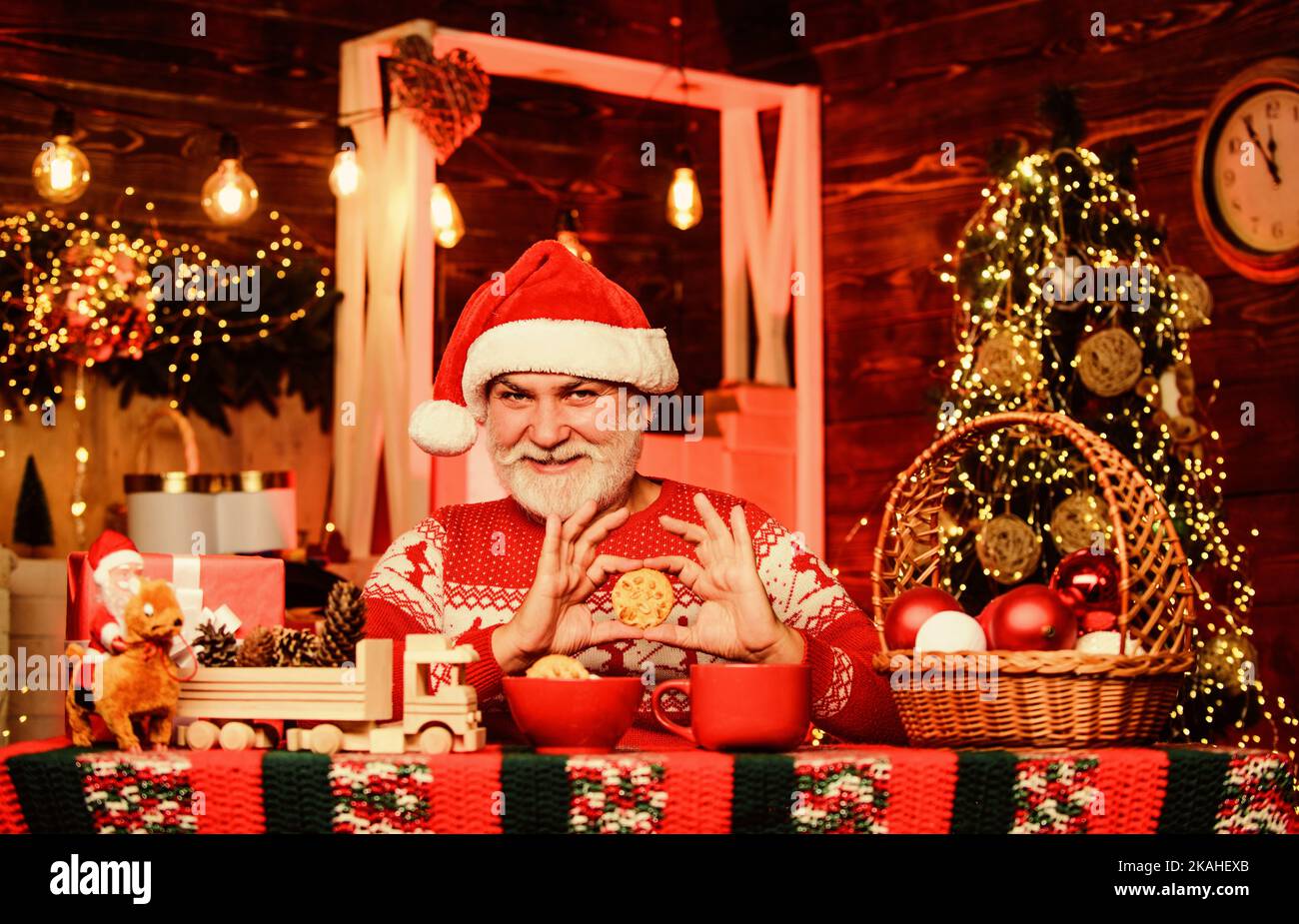 Christmas eve treats. Senior man Santa claus drinking tea. Christmas ...