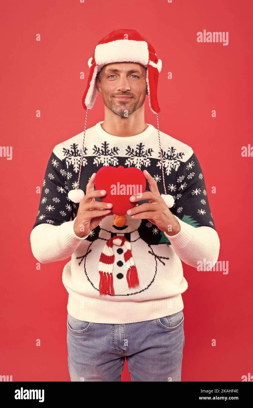 cheerful man in winter sweater and hat hold love heart on red ...