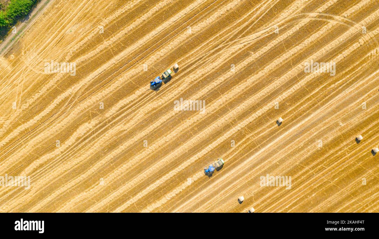 Above top view on two tractors as they pulling round baler, machines ...