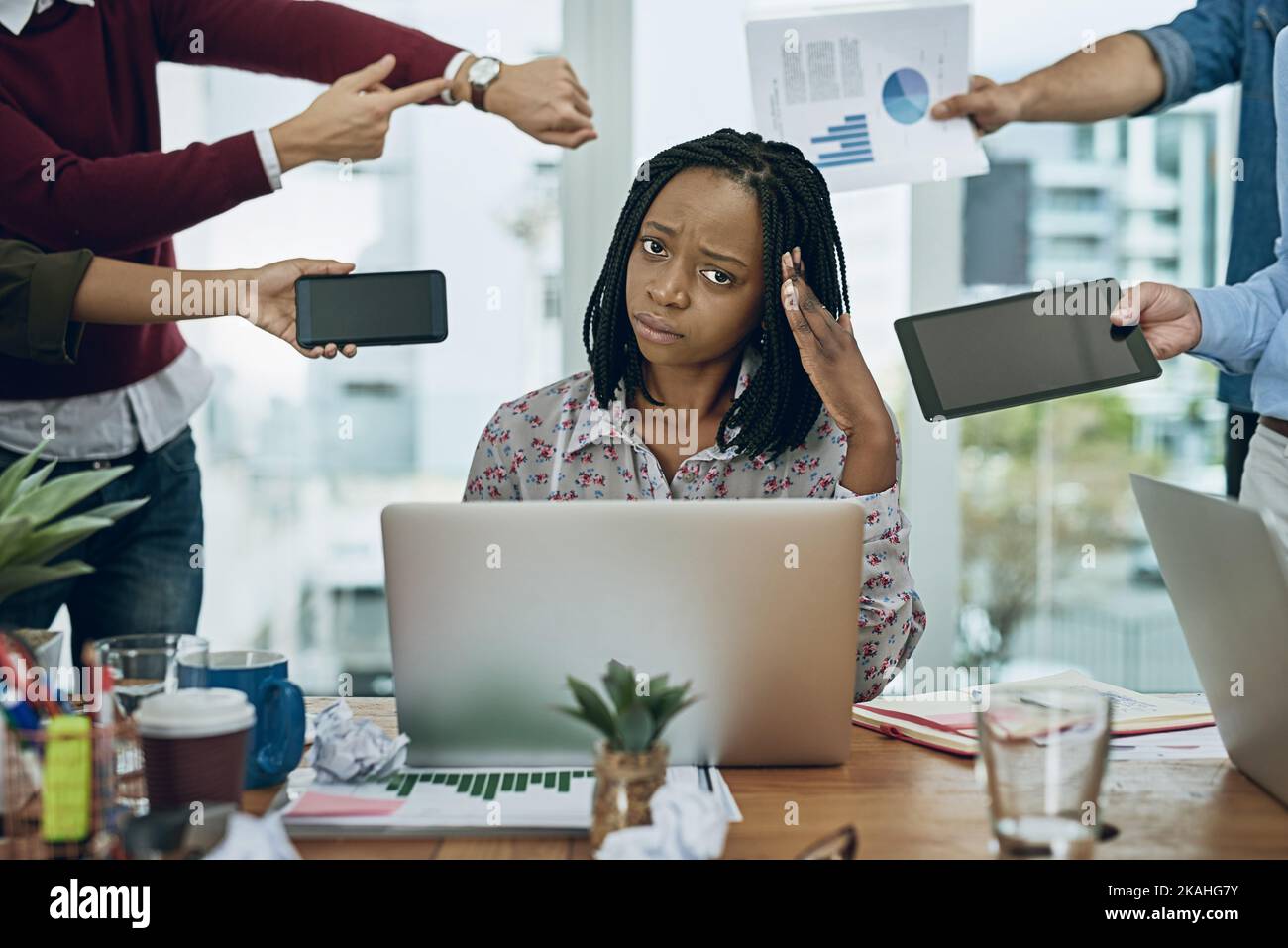 Trapped by unending work tasks. a young businesswoman looking stressed ...