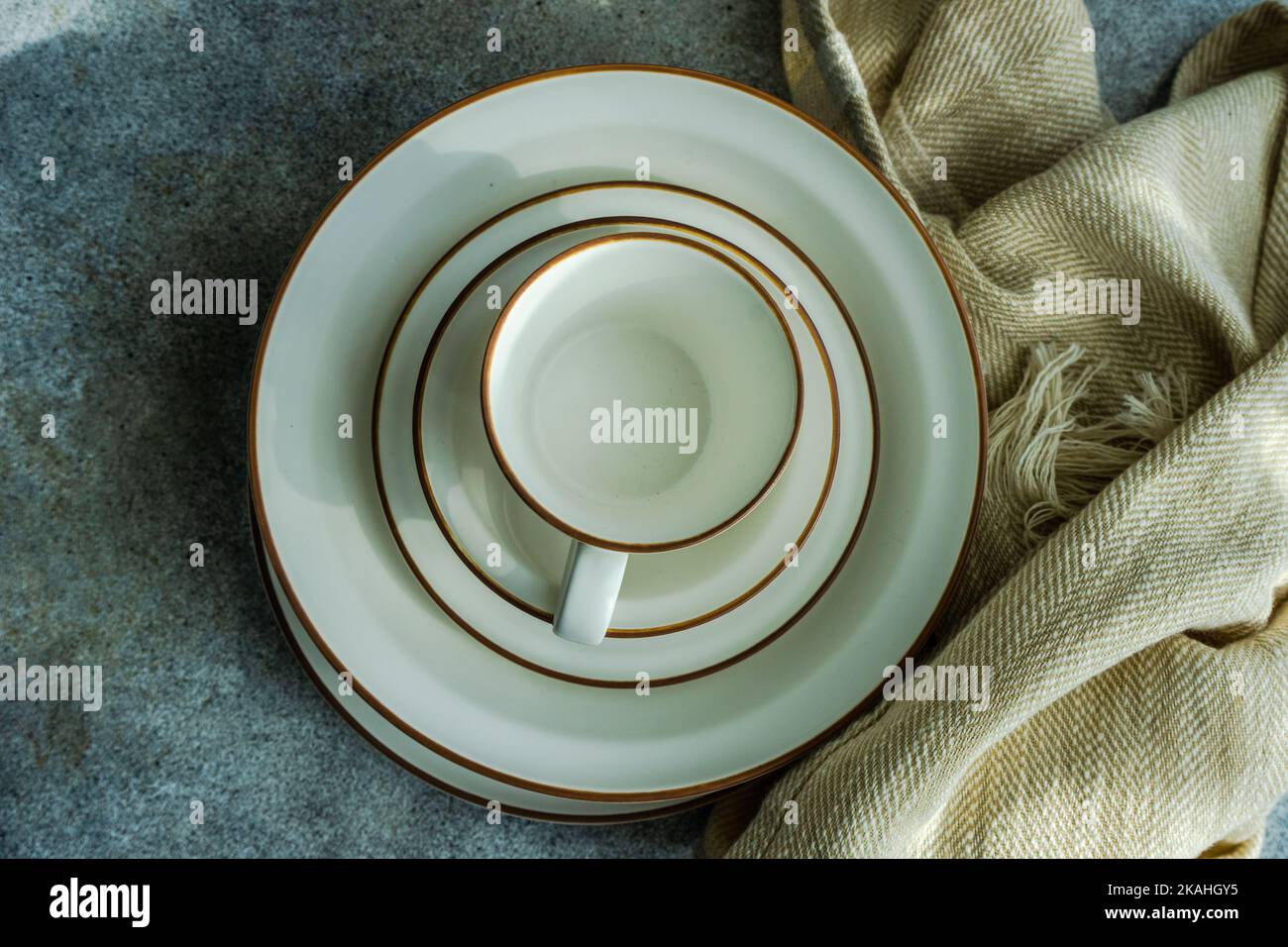 Overhead view of an empty coffee cup on a stack of bowls and plates ...