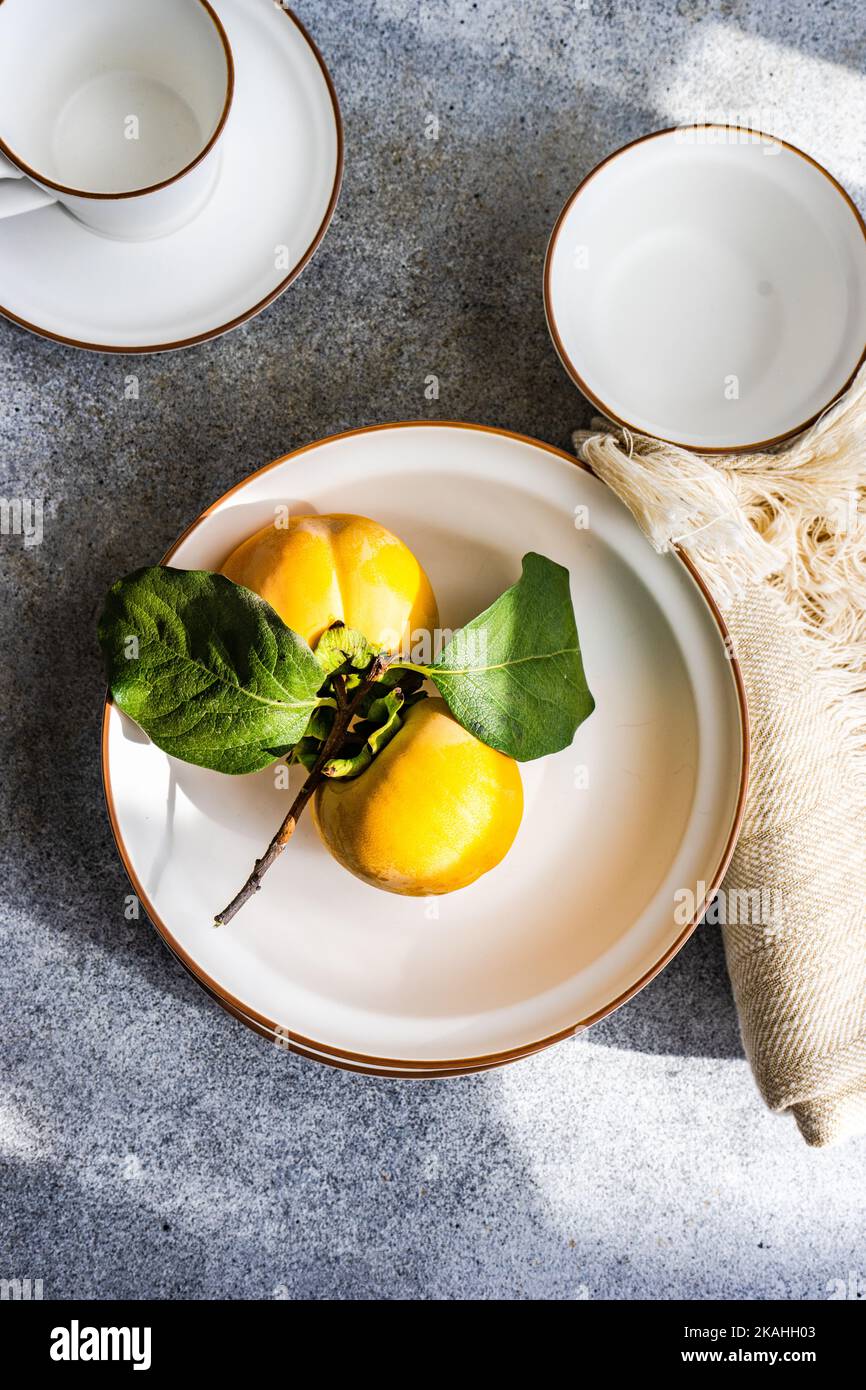 Overhead view of persimmon fruit and an empty coffee cup Stock Photo ...