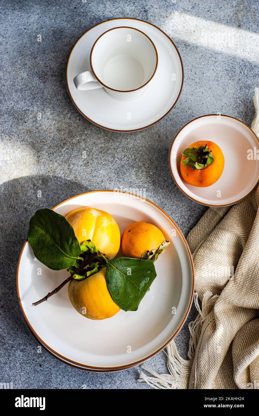 Overhead view of ripe persimmon fruits and an empty coffee cup Stock ...