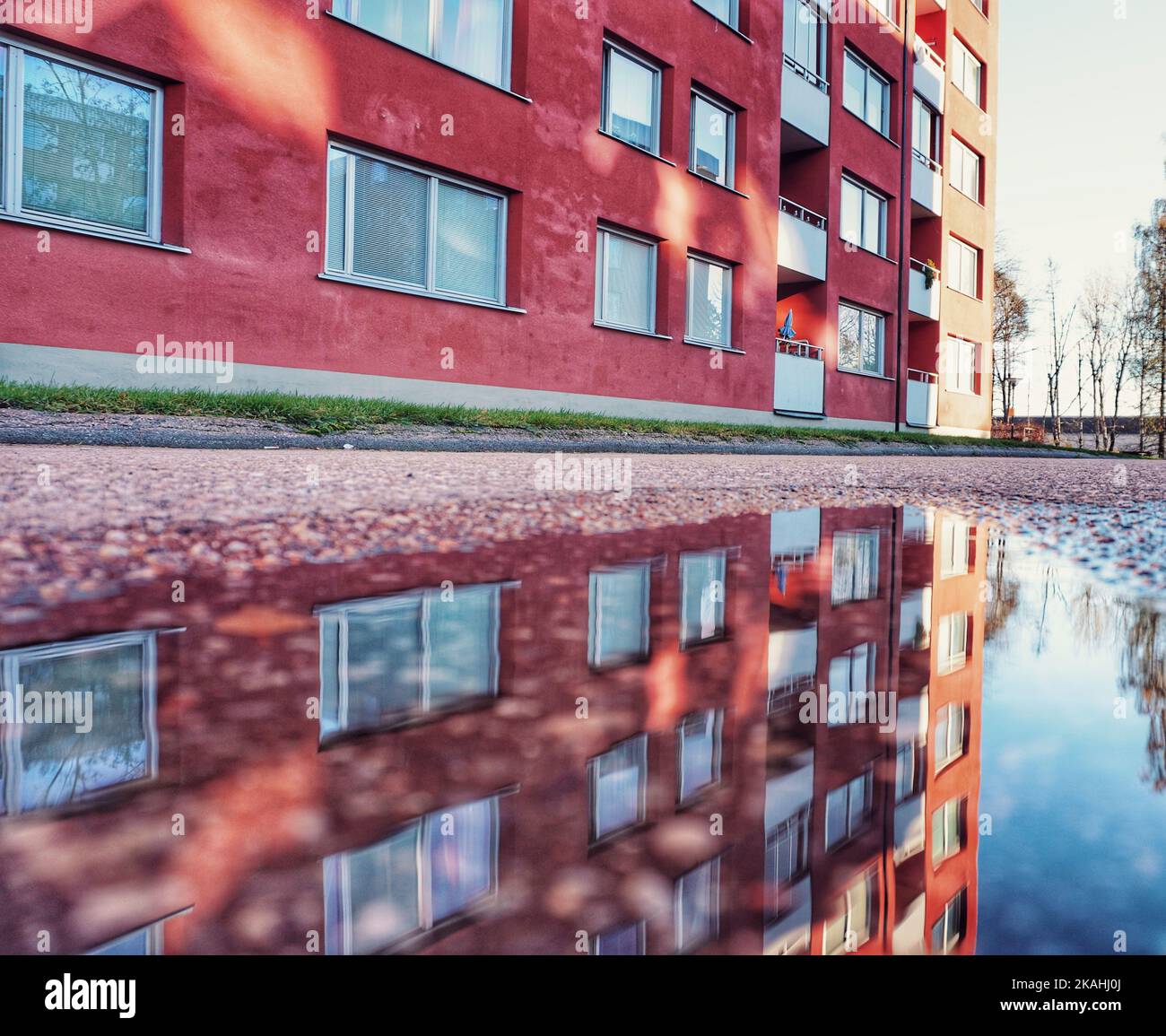 A puddle next to building during day Stock Photo - Alamy