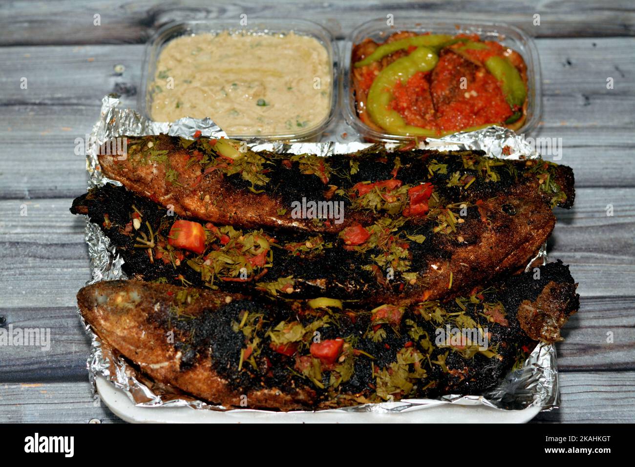 Charcoal grilled mullet fish with parsley and tomato, pickled eggplant ...