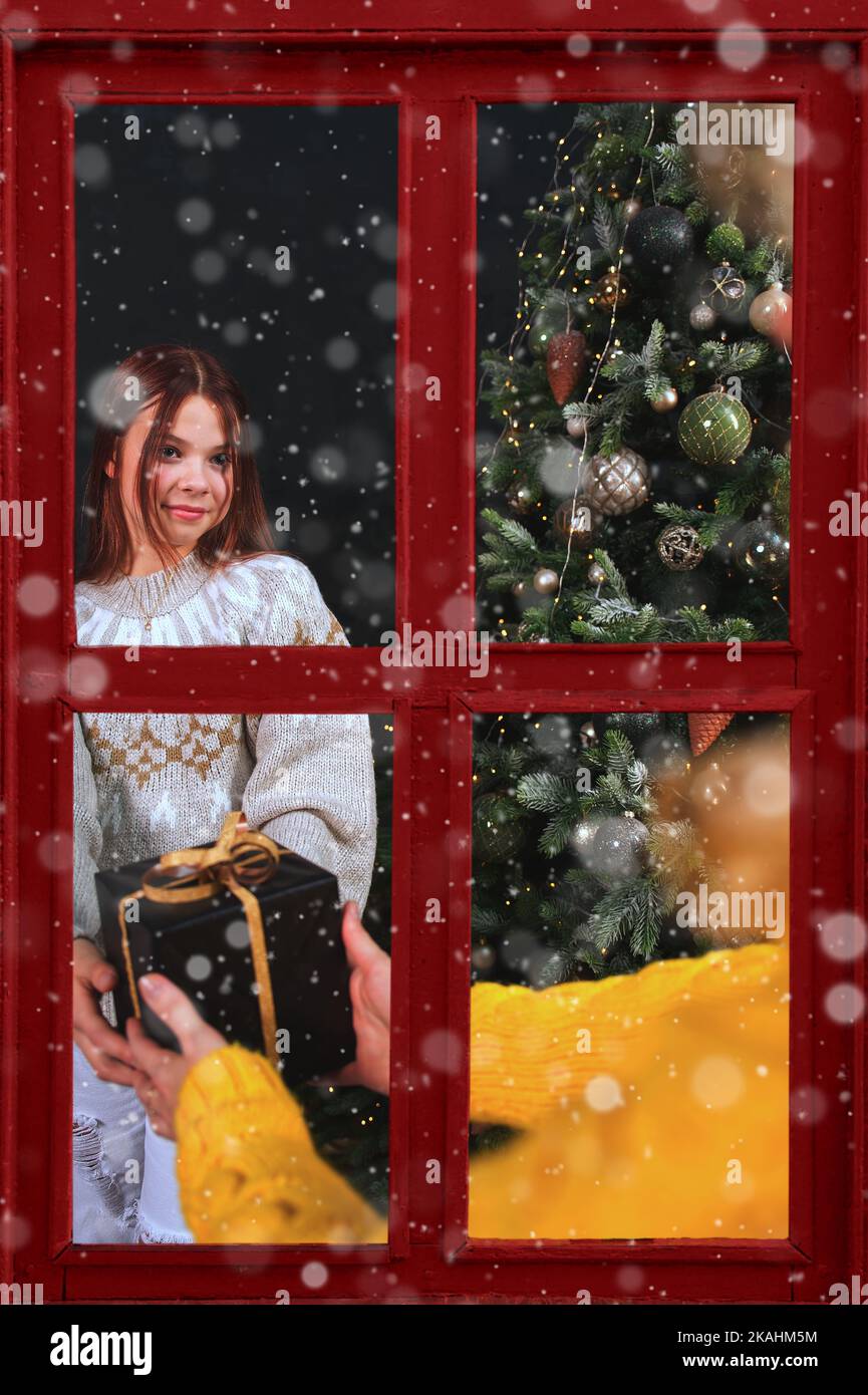 Christmas through the window. Christmas wonder. Mother gives her ...