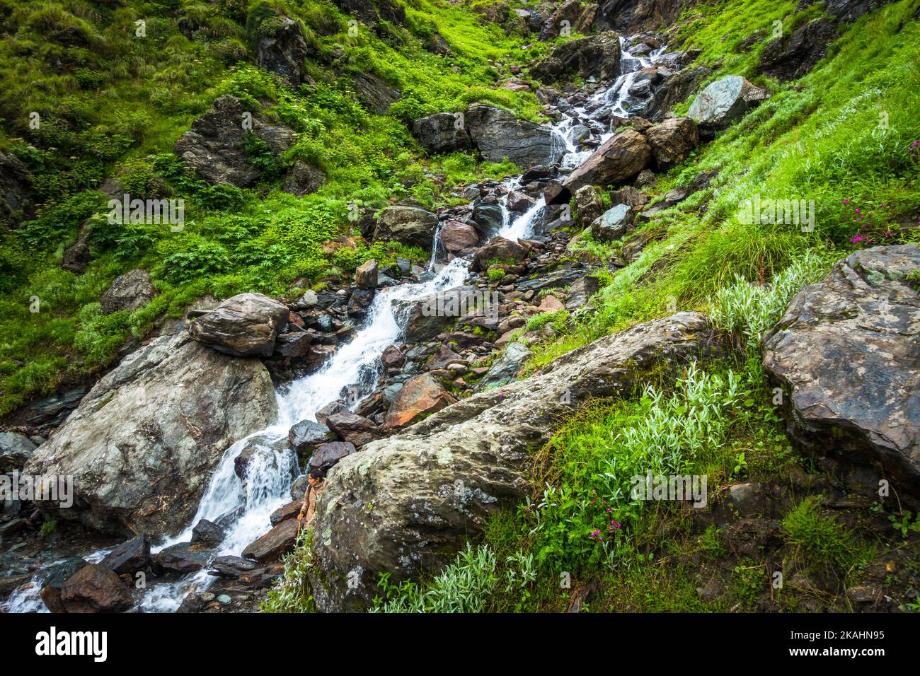 A water stream flowing down the mountain. Waterfalls at Shrikhand ...