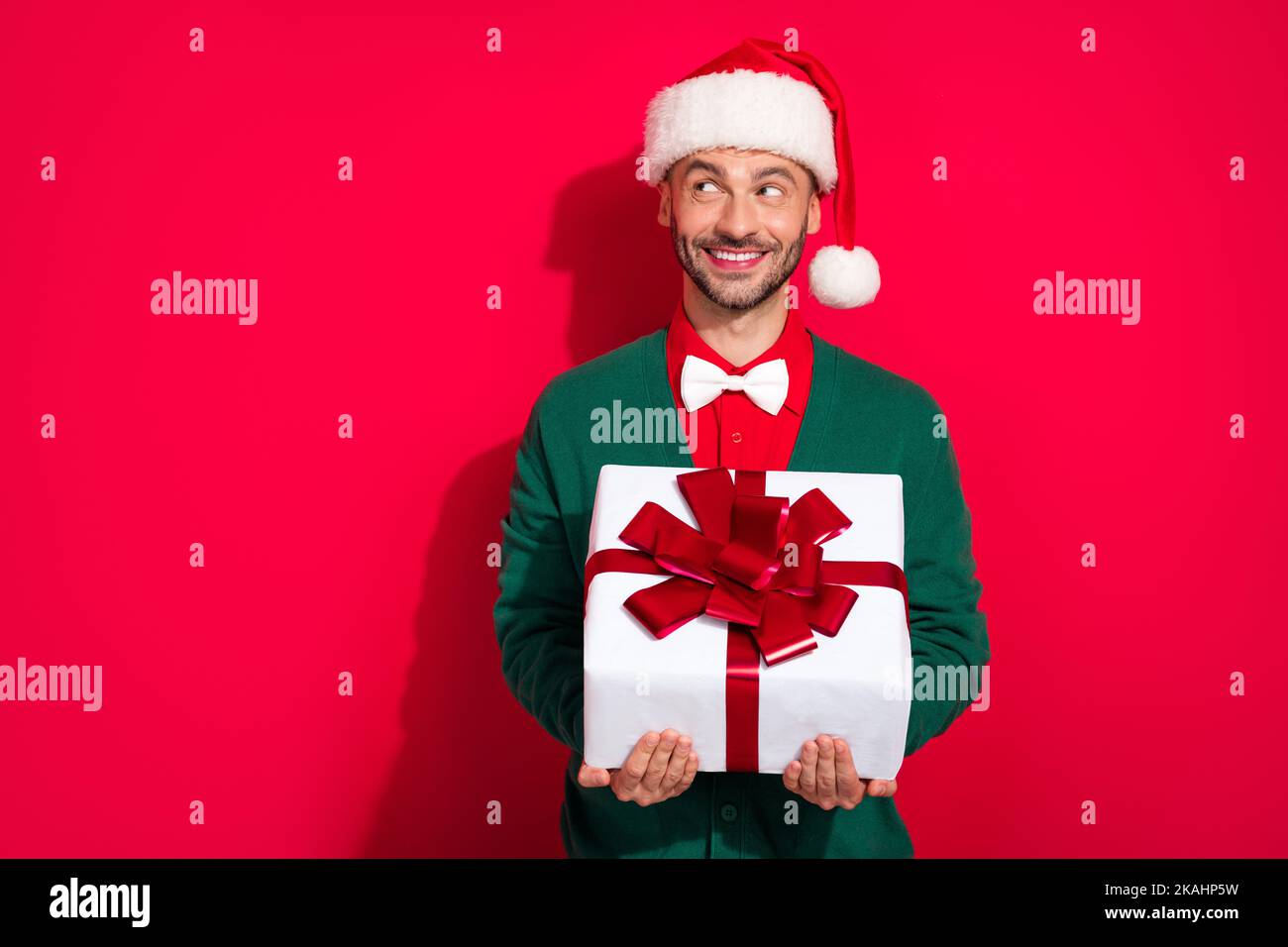 Photo of dreamy sweet man wear x-mas bowtie green cardigan packing noel ...