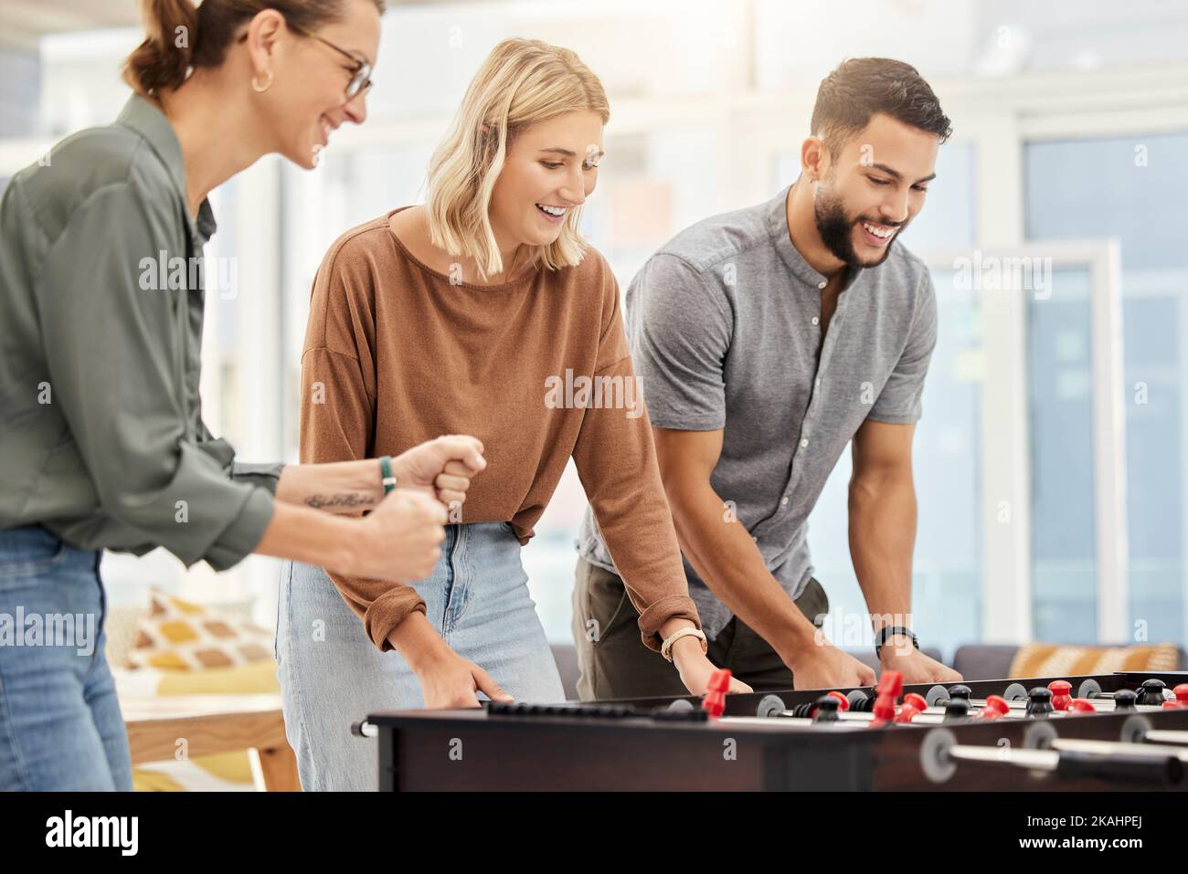 Business people play foosball table in office for team building ...