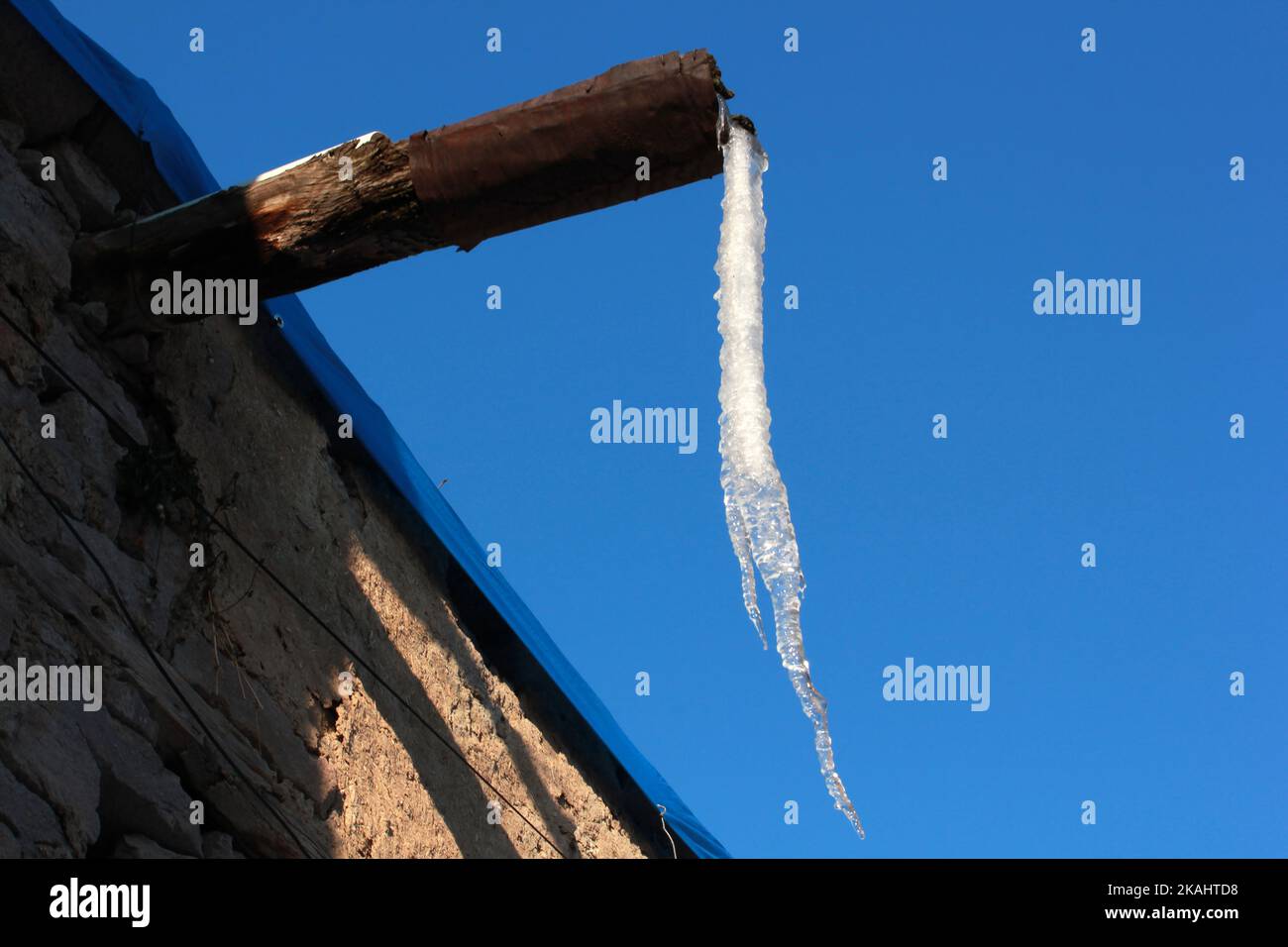 large icicle formed at the end of the roof gutter Stock Photo - Alamy