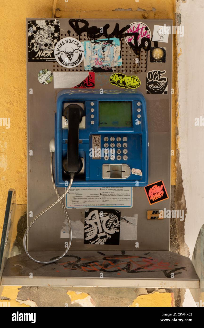 Greek blue pay phone, taken in Corfu. Fixed to an outside wall, in ...
