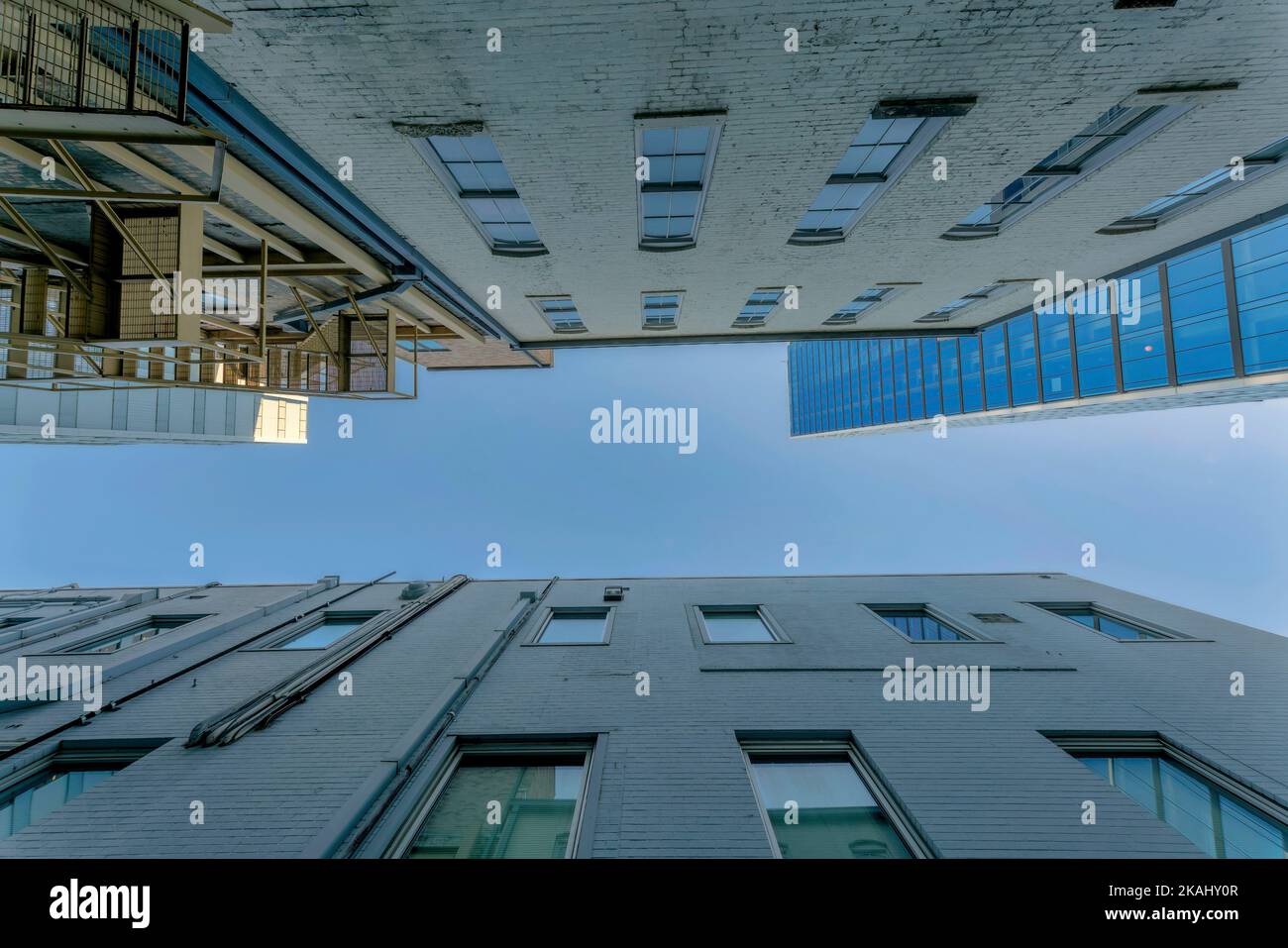 Looking up at apartments with brick wall and fire exit stairs at the ...