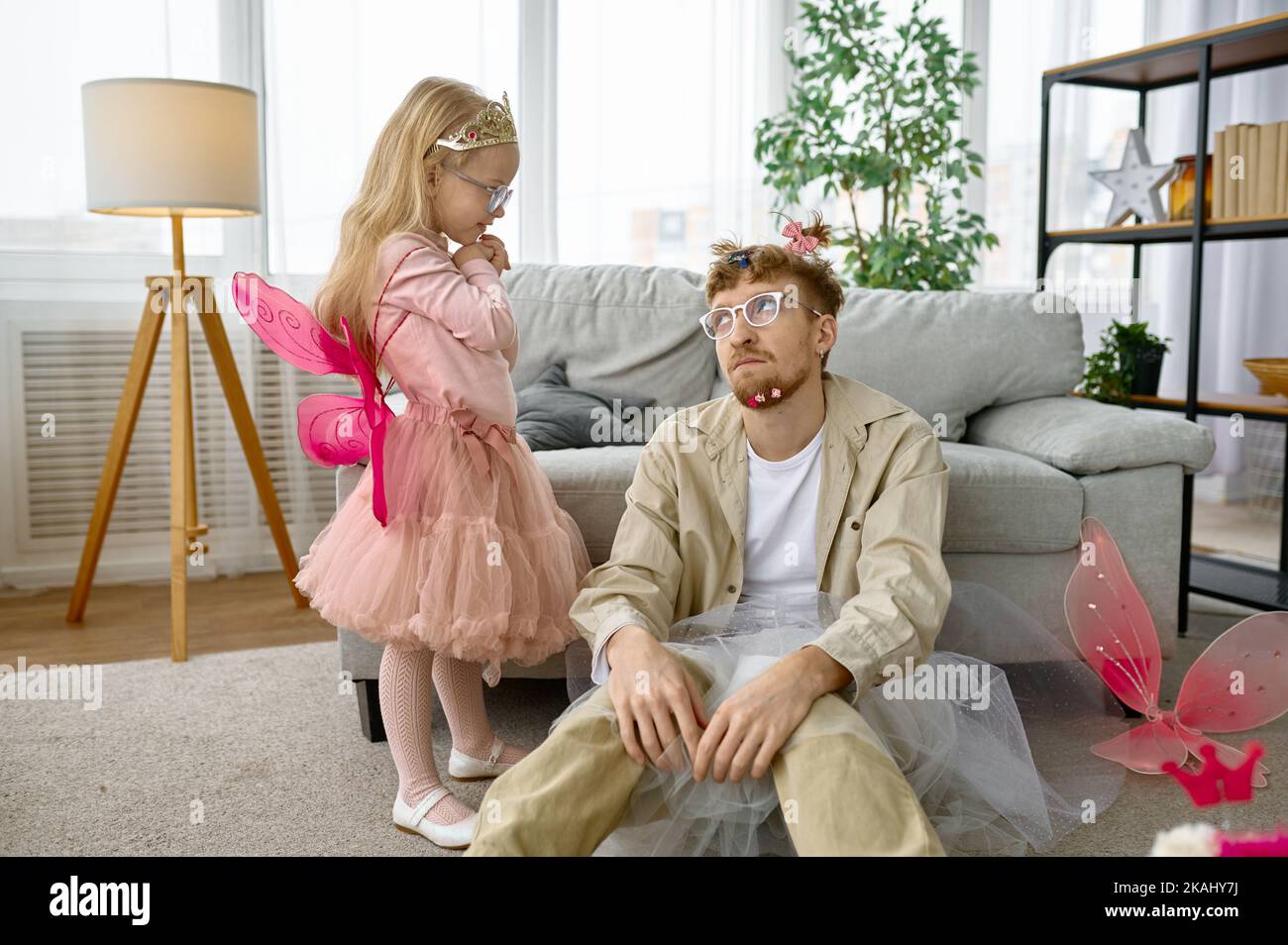 Tired father wearing having fun with daughter Stock Photo - Alamy