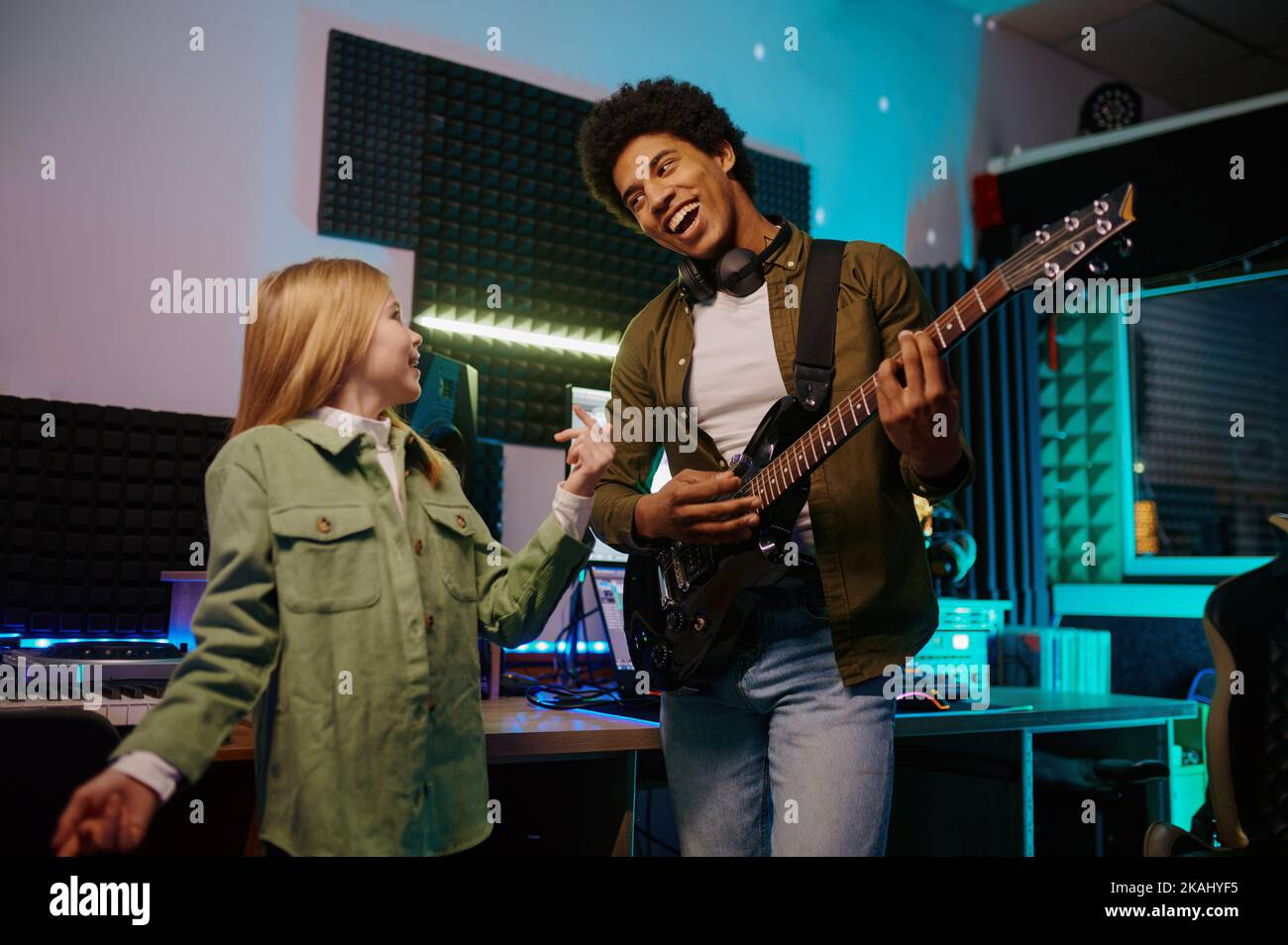 Young girl singing song mixing track with man guitarist Stock Photo - Alamy